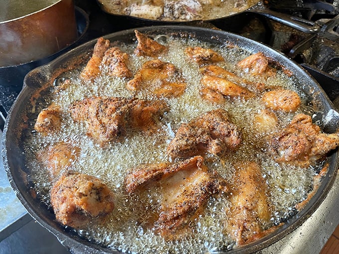 Culinary alchemy in progress &ndash; chicken pieces bubbling in their golden bath, transforming from ordinary to extraordinary right before your eyes.