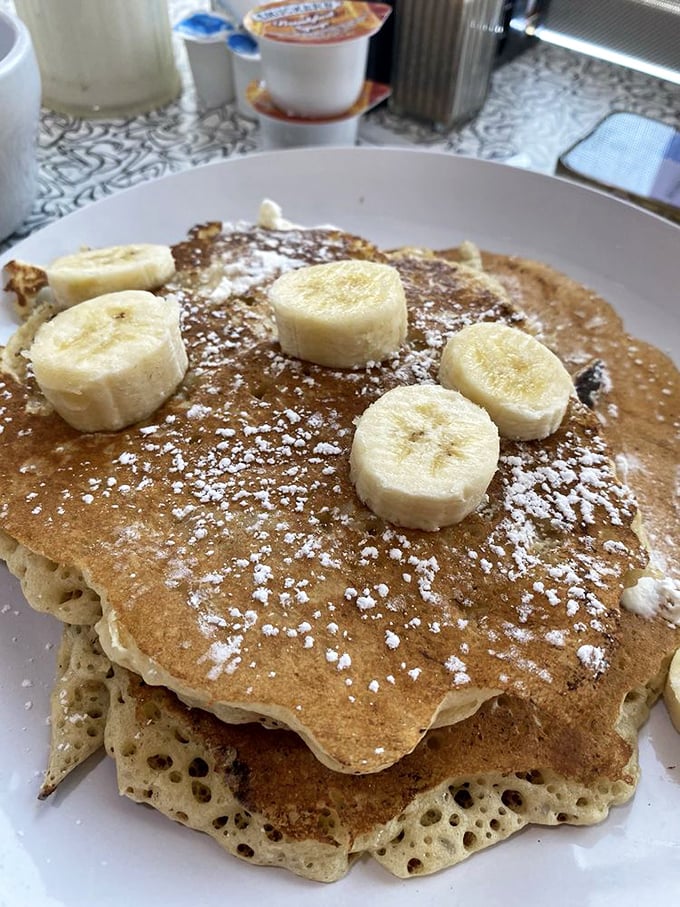 Pancakes so fluffy they could double as pillows, topped with banana slices and powdered sugar&mdash;breakfast or dessert? Why choose?