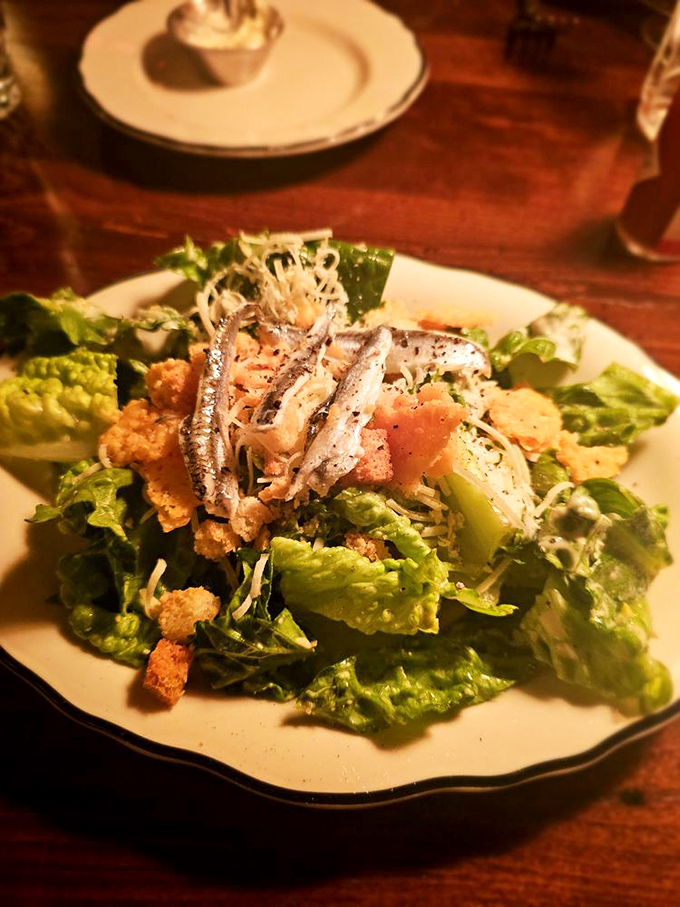 A Caesar salad that actually deserves attention. Those white anchovies aren't hiding &ndash; they're proudly announcing this isn't your average greens.
