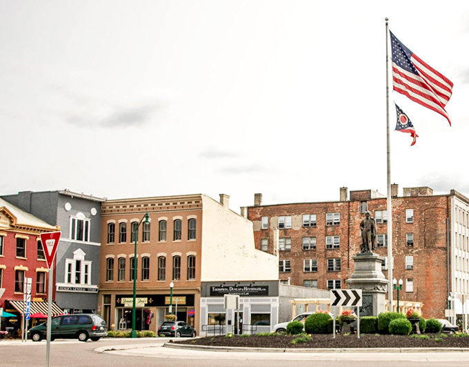 Monument Square's historic buildings stand proudly under American and Ohio flags, a patriotic postcard from the heart of small-town America.