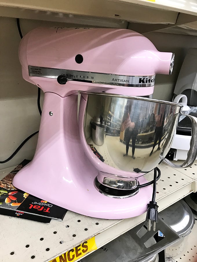 A pink KitchenAid mixer sits regally on its shelf, like culinary royalty waiting to be restored to its rightful throne in someone's kitchen.