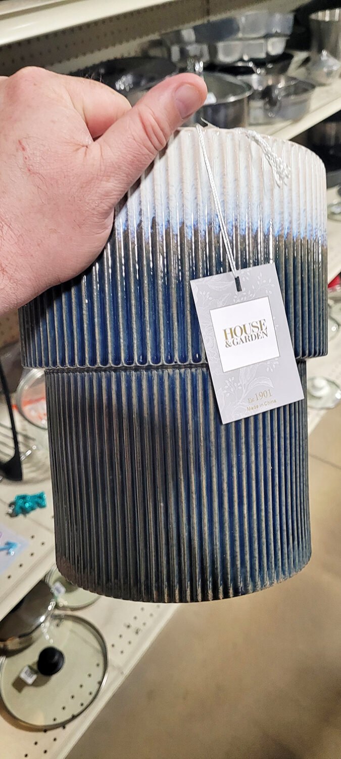 Someone's holding what could be the fanciest vase at the ball, complete with a designer tag that screams "I should cost way more!"