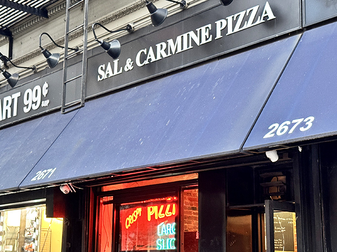 The "LARGE SLICE" neon glows like a promise in Sal & Carmine's window—pizza poetry in just two words.