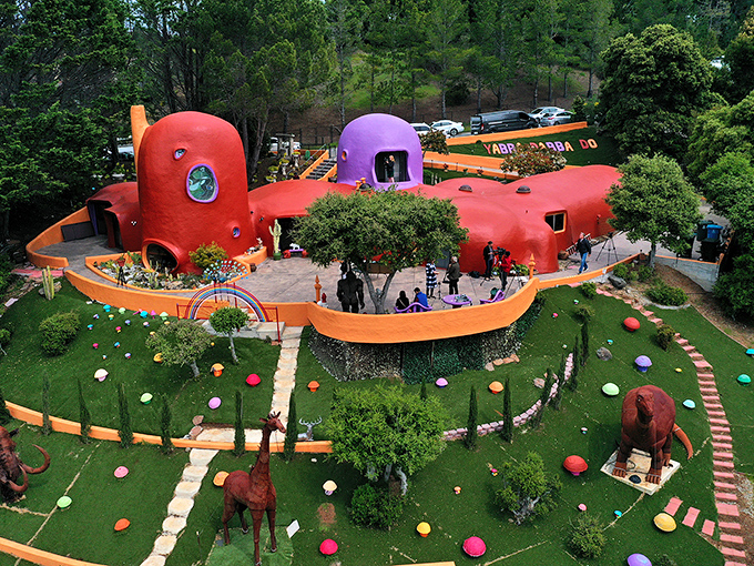 Dinosaur sculptures guard this bubble-shaped house, where modern Stone Age living gets a California twist.