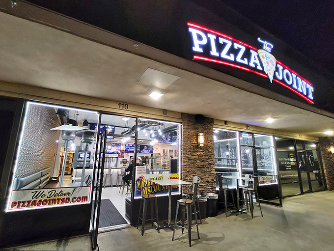 At night, The Pizza Joint's illuminated storefront promises comfort and satisfaction in every slice. Pizza therapy, now accepting walk-ins.