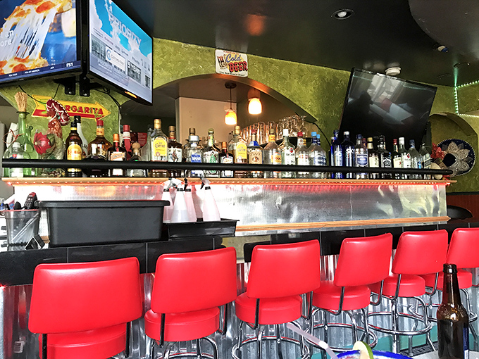 The bar showcases enough spirits to lift yours. Red chairs stand ready for those who believe tacos taste better with tequila.