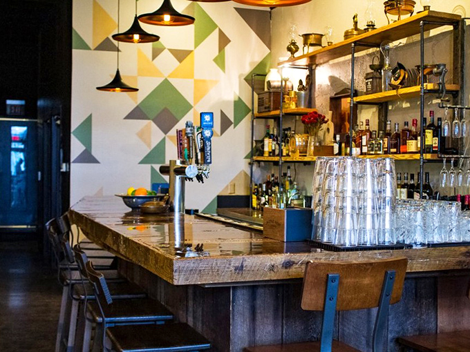 A bar that balances rustic and refined, where craft cocktails meet farmhouse charm under pendant lights that make everyone look good.