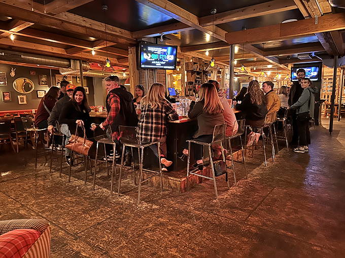 The bar area buzzes with energy as patrons perch on stools, watching bartenders craft cocktails worthy of the food that will soon arrive at their tables.