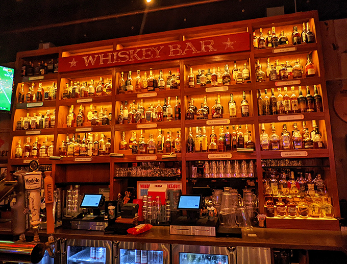 The Whiskey Bar sign glows like a beacon for bourbon pilgrims. Those illuminated shelves hold more stories than a small-town library.