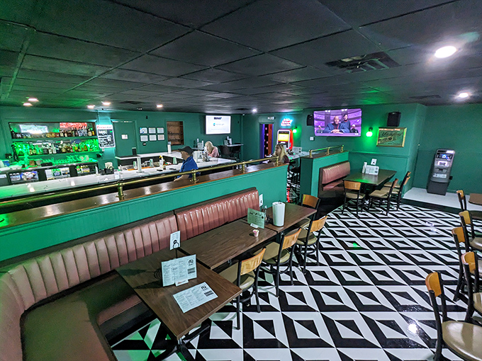 The bar area glows with an emerald invitation to stay awhile. Those geometric floors are practically begging for a sock hop.