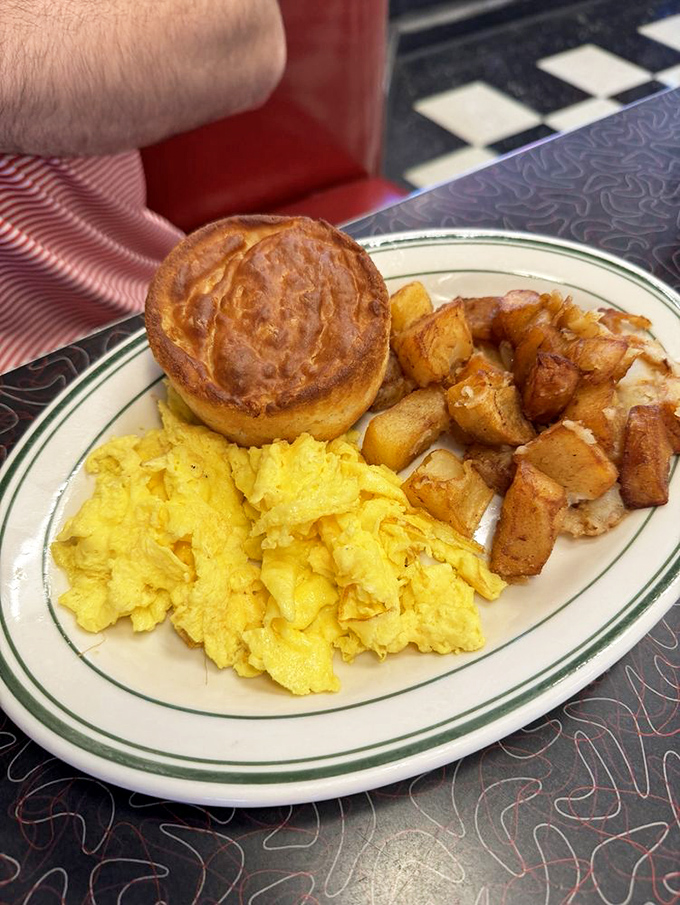 Breakfast perfection: scrambled eggs the color of sunshine, home fries with crispy edges, and a biscuit that would make your grandmother jealous.