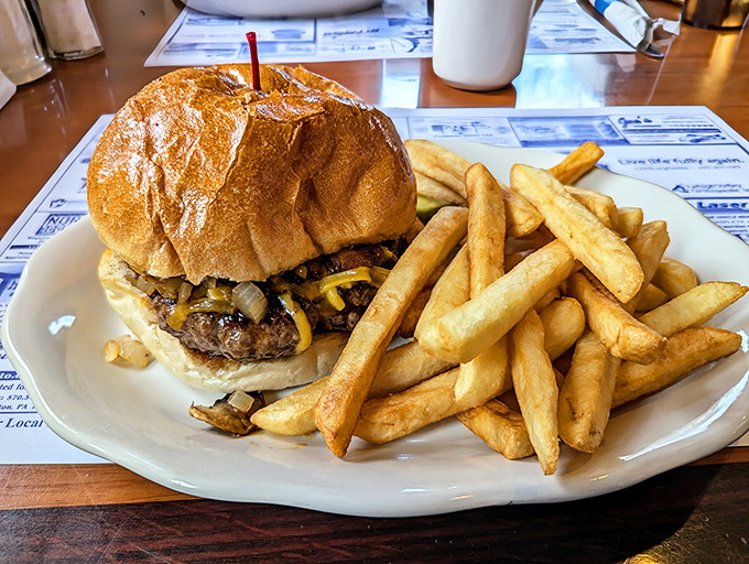 A burger that requires jaw-unhinging skills, accompanied by fries so perfectly golden they deserve their own Instagram account.