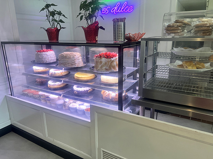 The "es dulce" neon sign isn't lying—this pastry case is where willpower goes to surrender in the most delicious way possible.