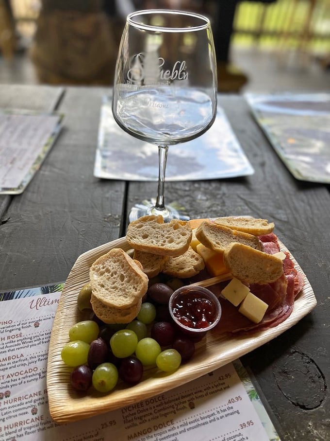 A wooden board of bread, cheese, and charcuterie waits patiently for its wine companion. Some matches truly are made in heaven.