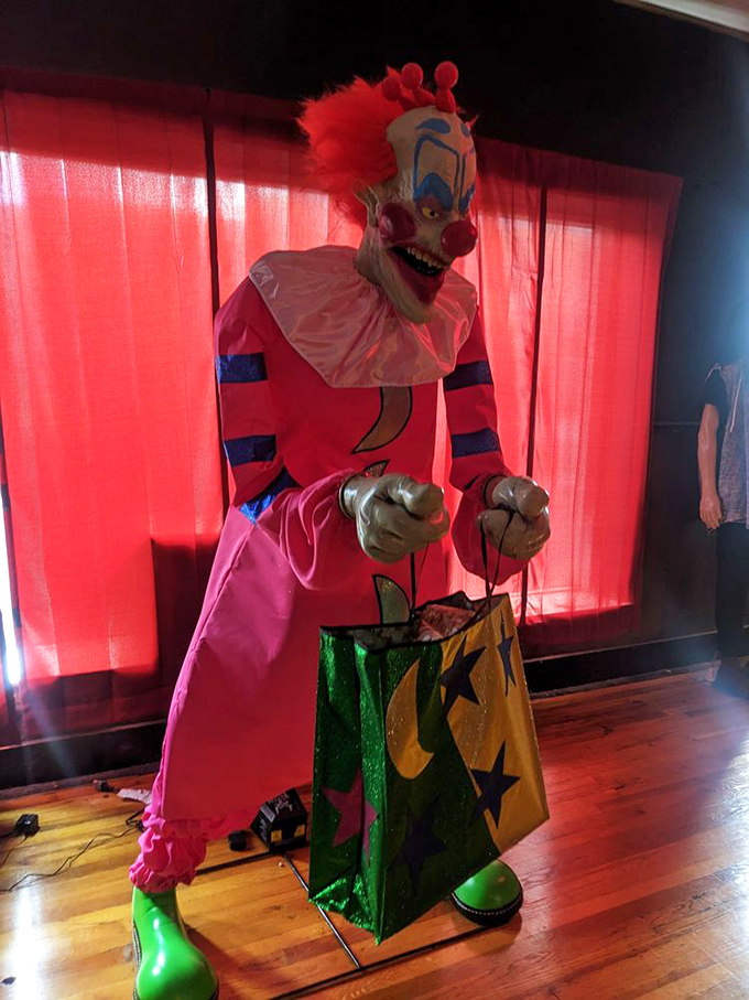 This vibrant clown statue holding a shopping bag perfectly captures that universal fear: encountering a clown while you're trying to do your errands.