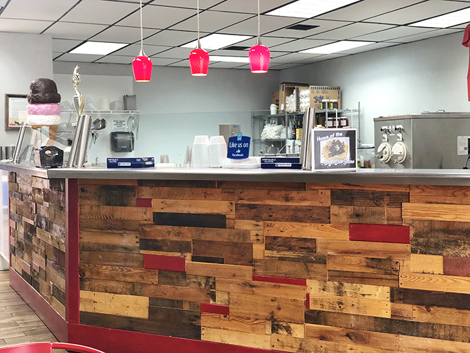 The counter's reclaimed wood panels tell stories while pink pendant lights cast a glow that makes everyone look like they've made excellent dessert choices.