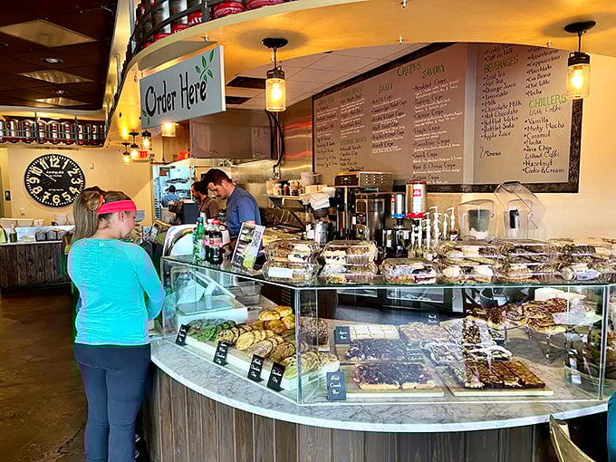 Behind this counter, breakfast wizards transform simple ingredients into morning masterpieces. The display case is basically a museum of carbohydrate artistry.