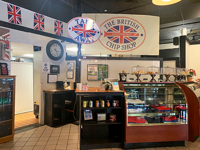 The counter area showcases British pride with flags and signage, while the pastry case tempts with authentic treats.