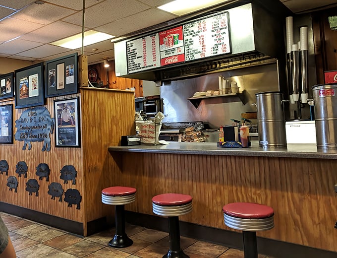 The counter where magic happens&mdash;red stools awaiting regulars, menu board overhead, and the promise of satisfaction just moments away.