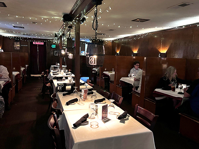 White tablecloths and wood dividers create dining sanctuaries where serious food appreciation happens without outside-world interruptions.