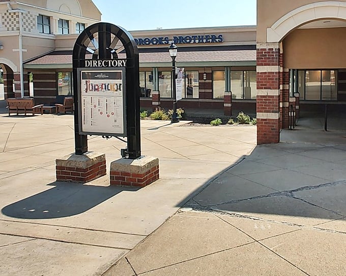 The directory stands like a retail lighthouse, guiding lost shoppers toward their next discount discovery beneath the Brooks Brothers sign.