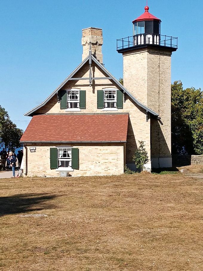 Eagle Bluff Lighthouse stands like a retired sea captain telling tales of storms past. Stone walls that have weathered more Wisconsin winters than your favorite flannel.