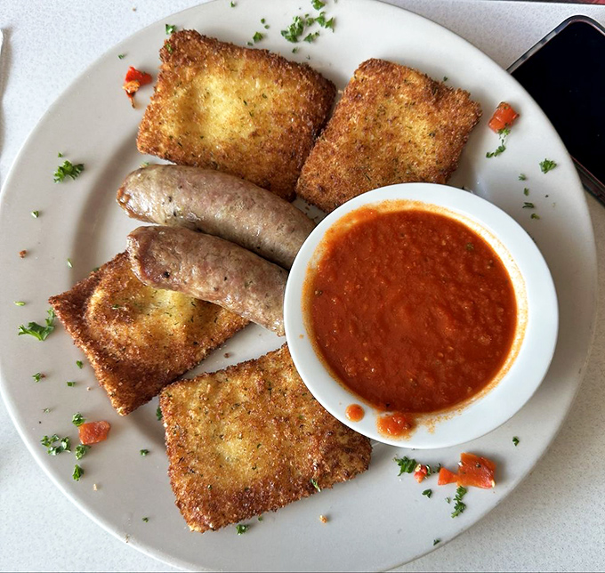 Golden-fried ravioli squares surround Italian sausage links like delicious bodyguards, with marinara sauce standing by for dipping duty.