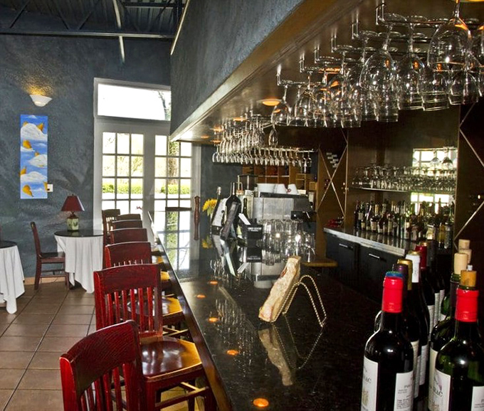 The bar at Petite Violette doesn't just serve drinks—it serves possibilities, all lined up in gleaming bottles against a backdrop of anticipation.