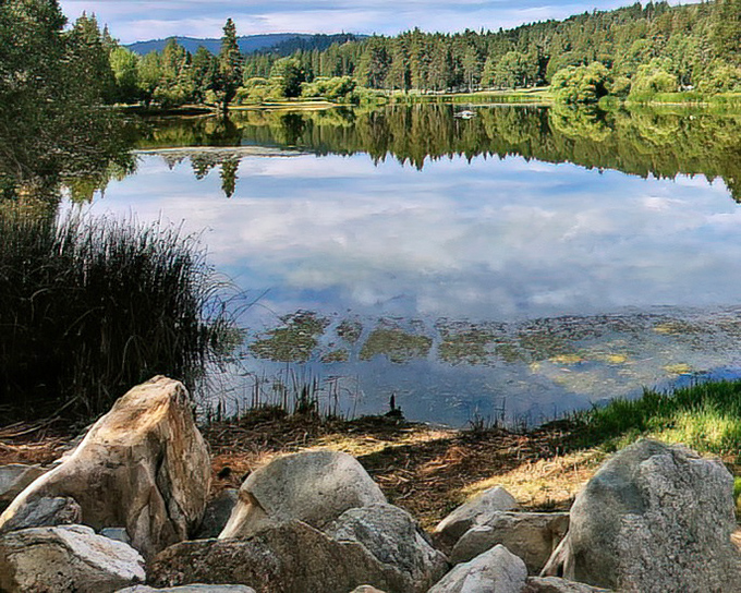 Mirror-like waters reflect the surrounding pines at Grass Valley Lake, nature's own infinity pool without the maintenance fees.