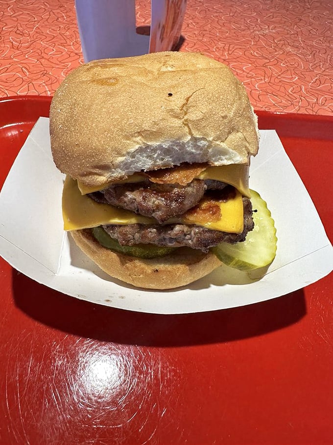The double cheeseburger that requires a game plan before the first bite. Two beef patties, cheese, and pickles stacked higher than a Packers defensive line.