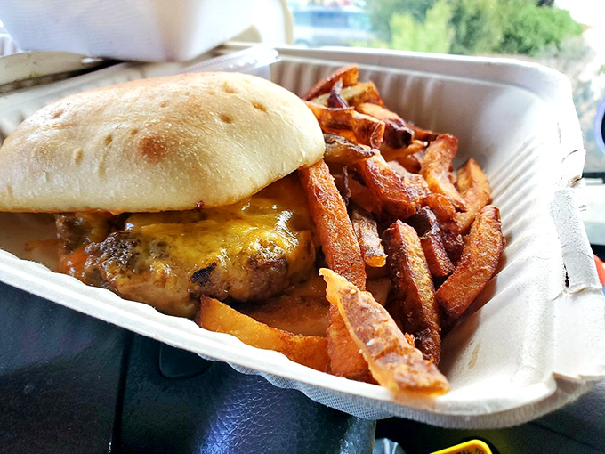 A burger that demands to be photographed before eaten, paired with sweet potato fries that might upstage the main attraction.