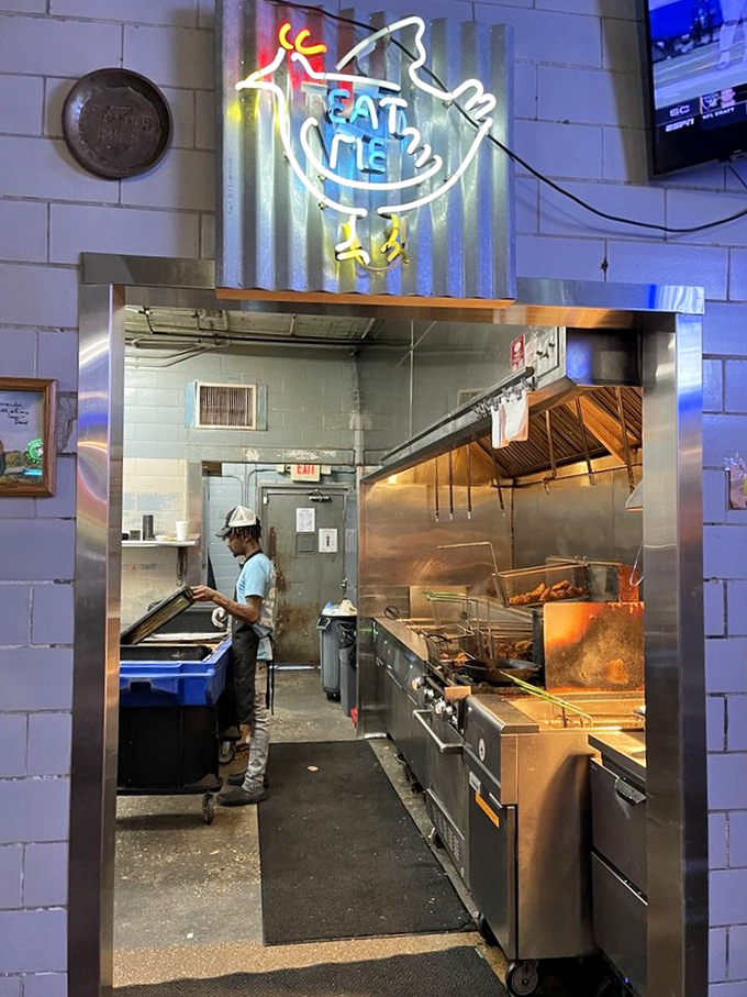 Behind the "Eat Chicken" neon sign, kitchen magic happens. This window to wonderland shows where ordinary poultry becomes extraordinary.