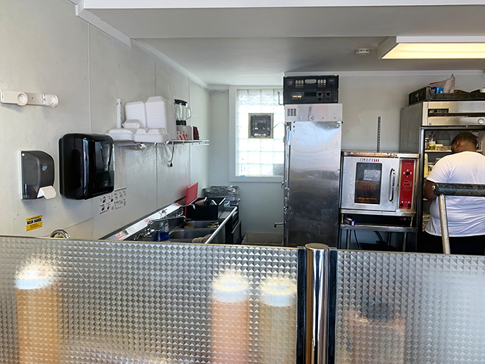 A glimpse behind the curtain reveals the compact kitchen where sandwich magic happens. No fancy equipment, just skilled hands and quality ingredients.