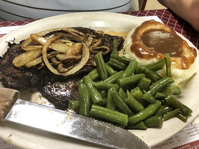 Steak with sautéed onions and green beans that haven't forgotten their connection to actual gardens.