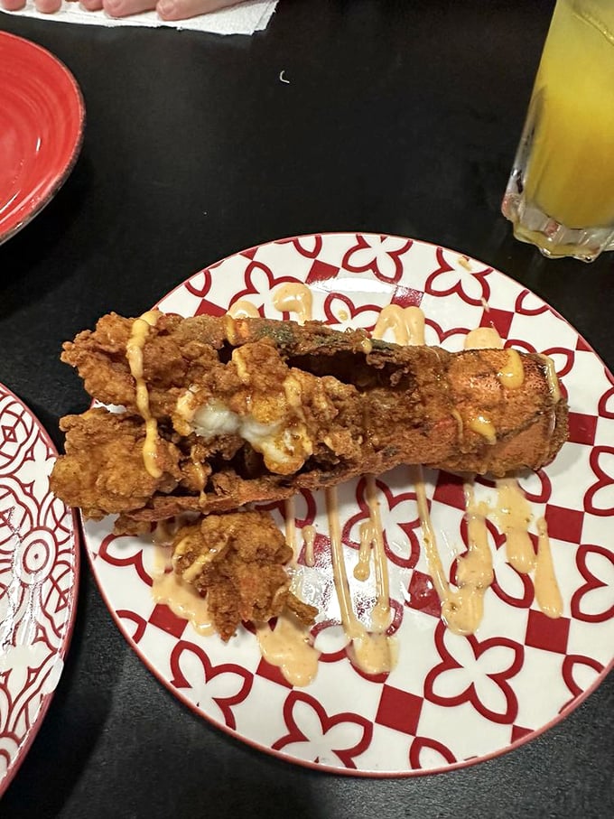 This isn't just fried lobster &ndash; it's crustacean transformation. Crispy exterior giving way to sweet meat, with sauce artfully drizzled like culinary calligraphy.