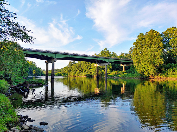 The Oconee River flows beneath the bridge like liquid glass, reflecting Georgia's generous sky and offering a moment of tranquility that no spa treatment can match.