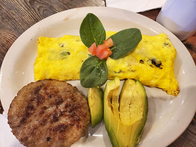 This omelet, garnished with fresh spinach and avocado, proves healthy options can coexist beautifully with diner indulgence.