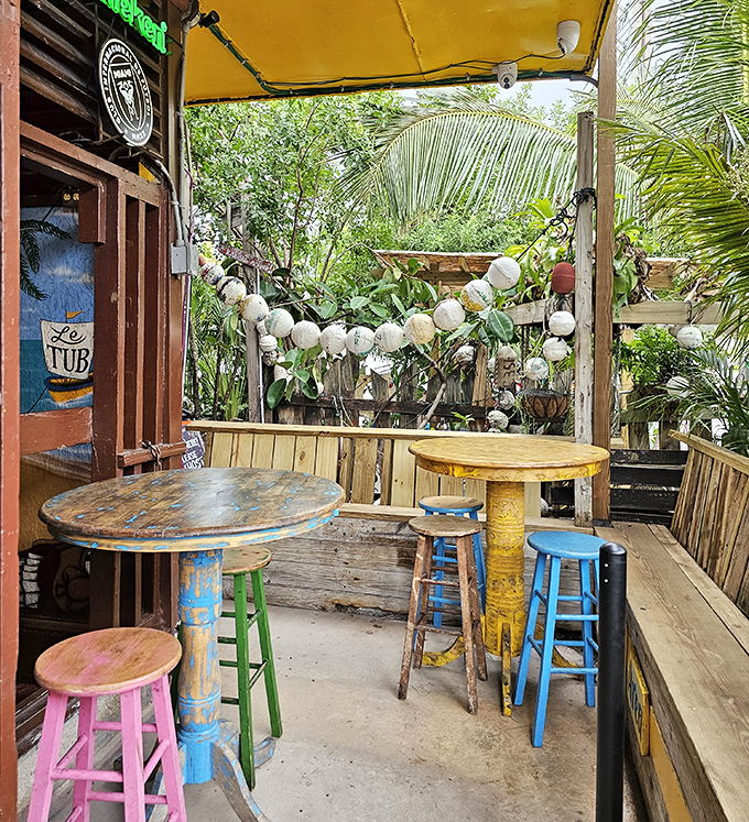 The mismatched furniture and jungle-like surroundings create the perfect "lost paradise" vibe for enjoying seafood just steps from the water.