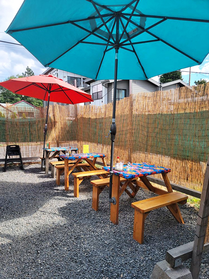 Picnic tables under turquoise umbrellas create that "I've discovered something special" vibe that makes every bite taste even better.