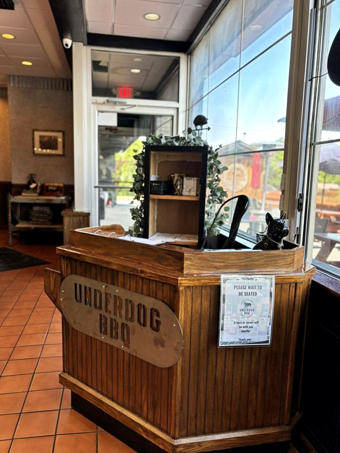 The rustic wooden host stand welcomes you like an old friend, complete with a small black bulldog statue standing guard.