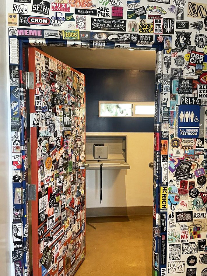 A restroom entrance that's a gallery of punk rock history. Even the bathroom break becomes part of the experience here.