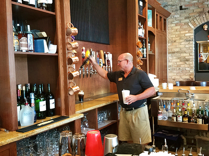 The art of the perfect pour in action. A skilled bartender tends to the impressive array of taps, ensuring each pint meets the exacting standards of British tradition.
