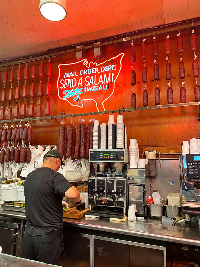 Behind that neon "Send A Salami" sign stands a maestro of meat, conducting a symphony of slicing that's been perfected over decades.