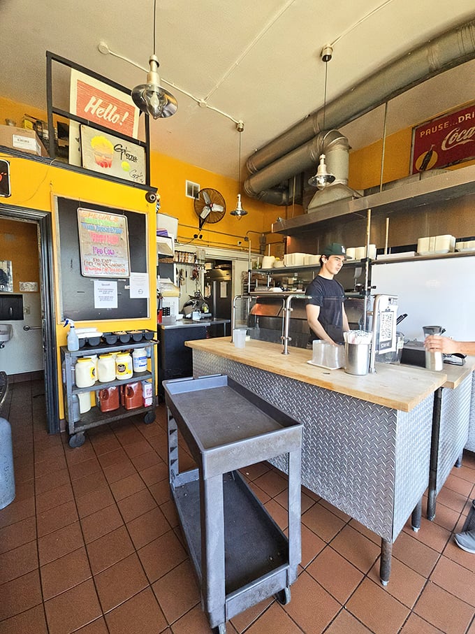 The compact, sunshine-yellow interior makes efficient use of space—like a well-choreographed culinary ballet in constant motion.