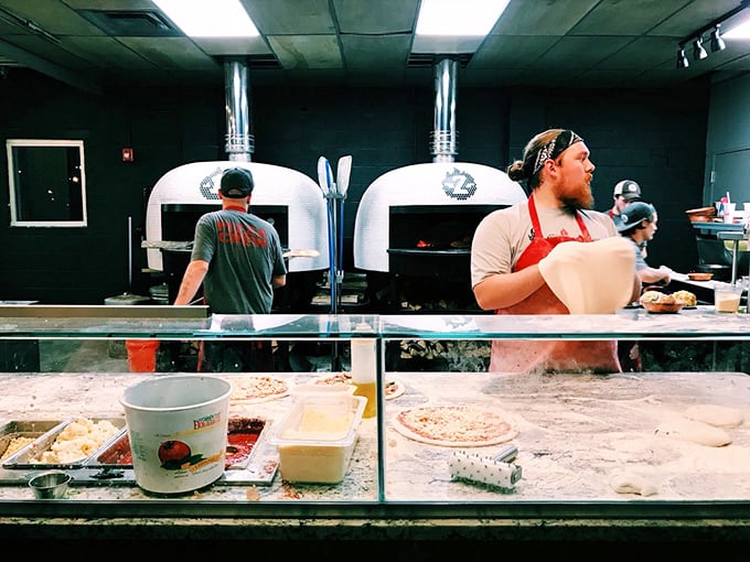 Pizza artisans at work, transforming simple dough into edible art. Those aren't just ovens&mdash;they're portals to flavor country, burning hot enough to cook a pizza in 90 seconds.