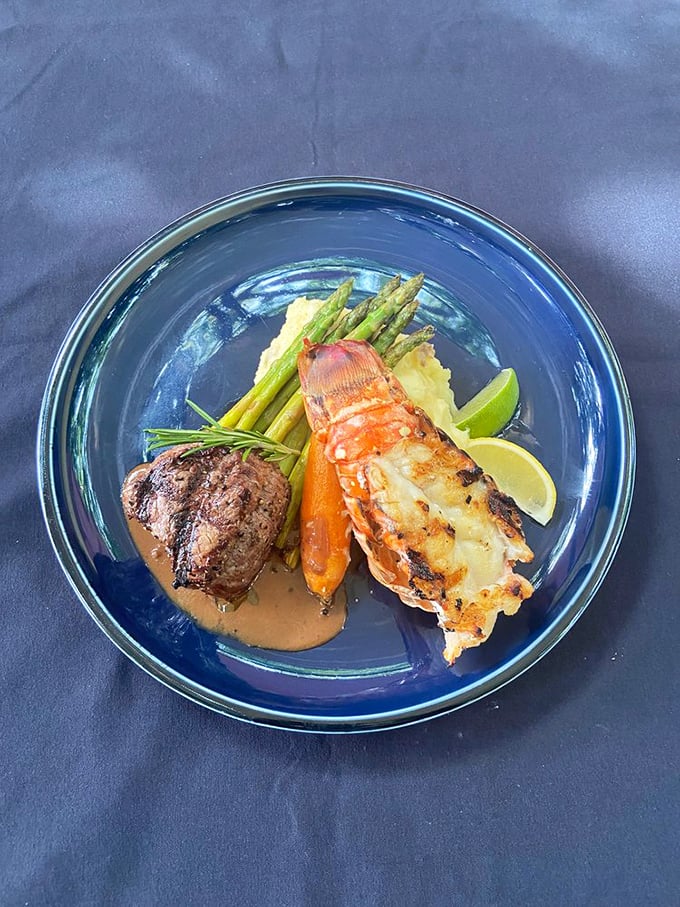 Surf meets turf in a blue bowl of culinary diplomacy. The lobster tail and filet mignon have clearly signed a delicious peace treaty.