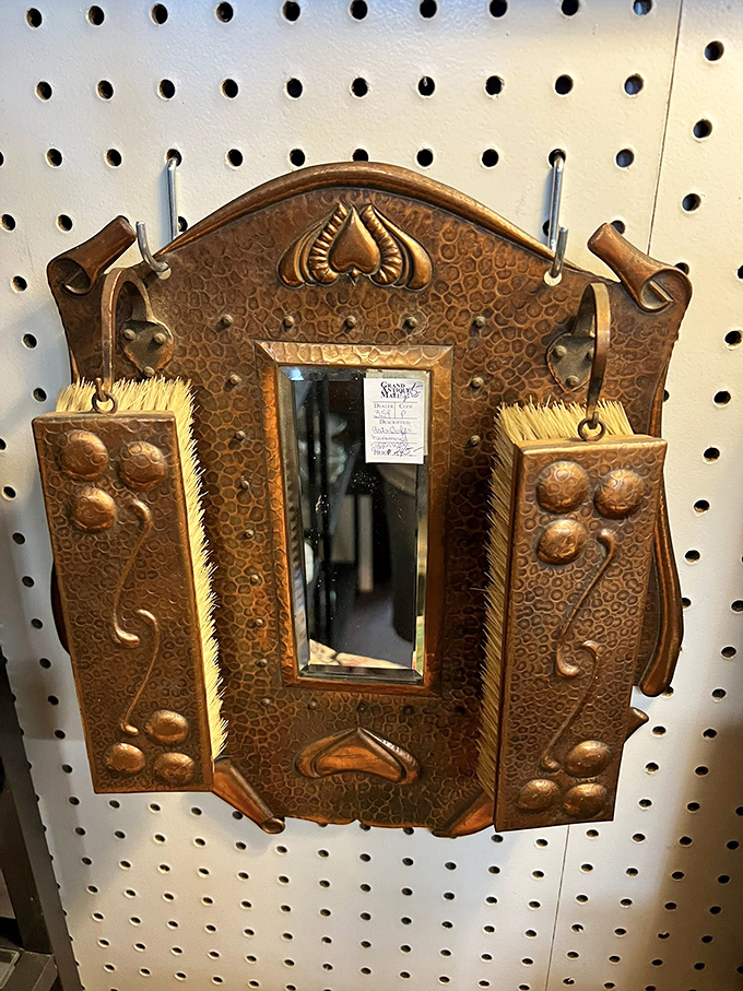A copper-framed mirror flanked by brushes that once tamed someone's locks during the Roaring Twenties. Morning routines were simply more elegant then.