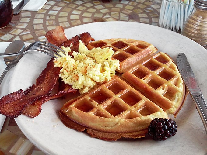 A golden waffle with eggs and bacon&mdash;the holy trinity of breakfast. That blackberry isn't just fruit; it's nature's perfect punctuation mark.