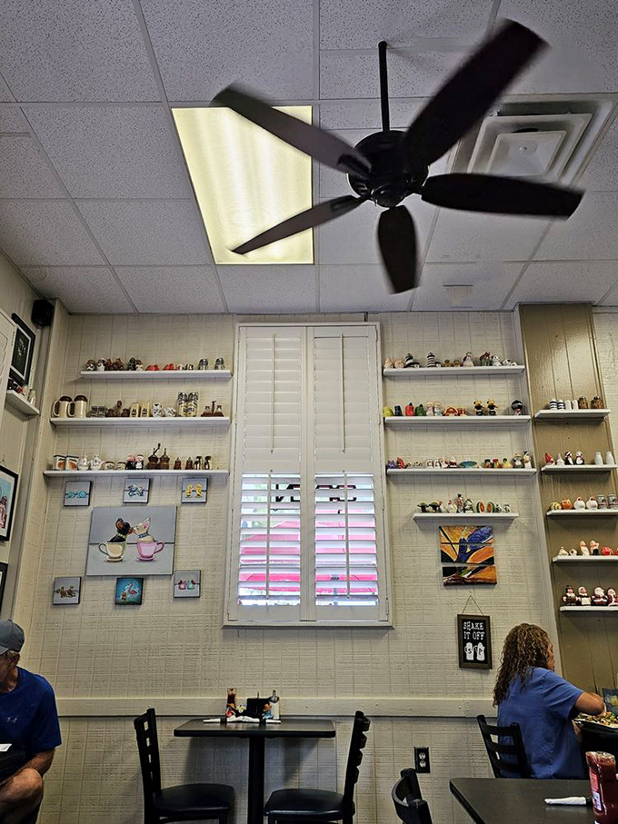 The salt and pepper shaker collection lines the walls like tiny sentinels guarding breakfast traditions. Each one has a story; sadly, they're not telling. 