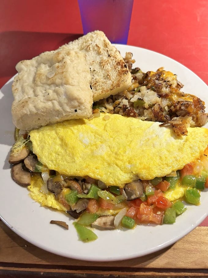 An omelet that's practically a garden party with mushrooms and peppers as the VIP guests. That biscuit deserves its own fan club.